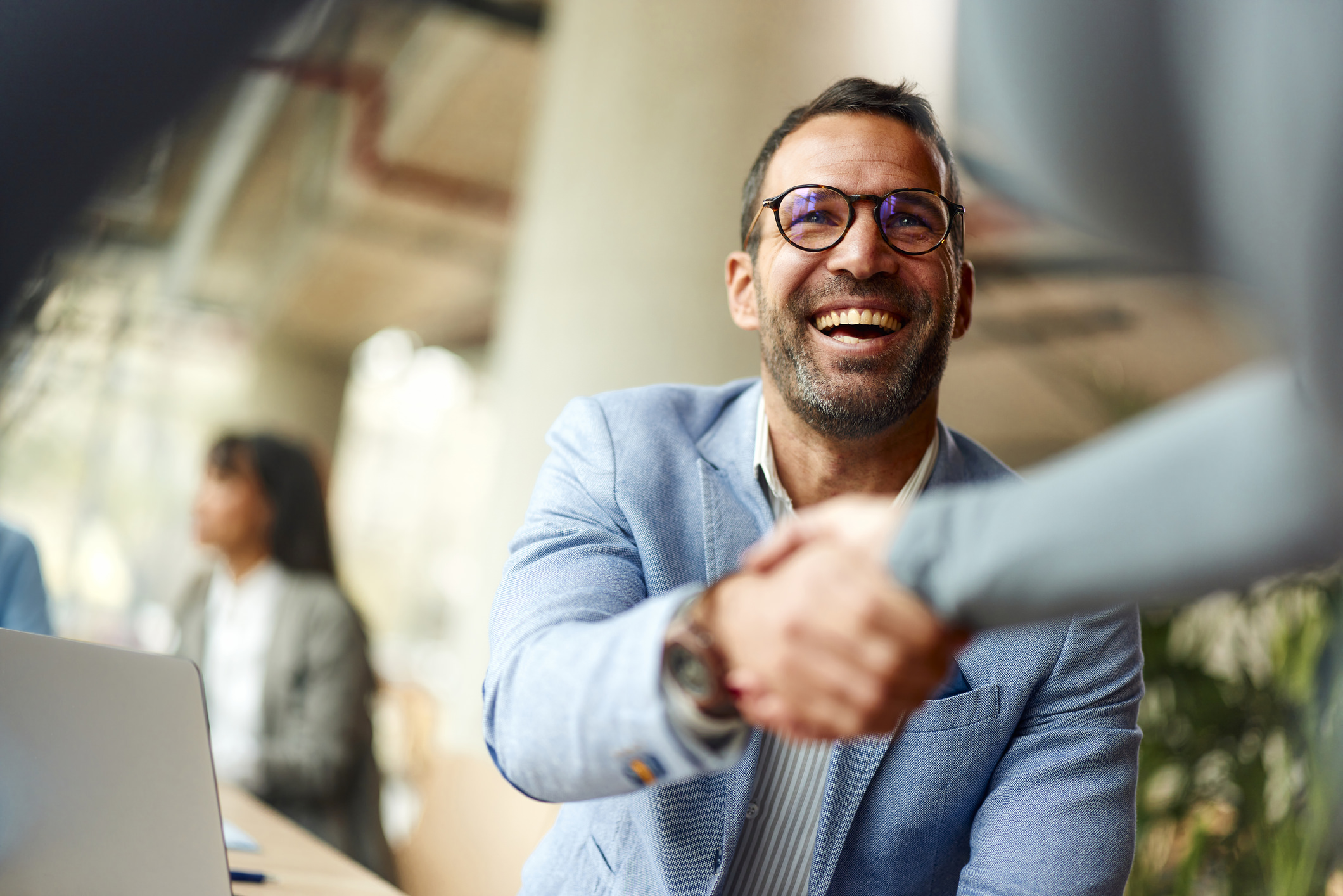 Happy businessman shaking hands with his colleague on a meeting in the ...
